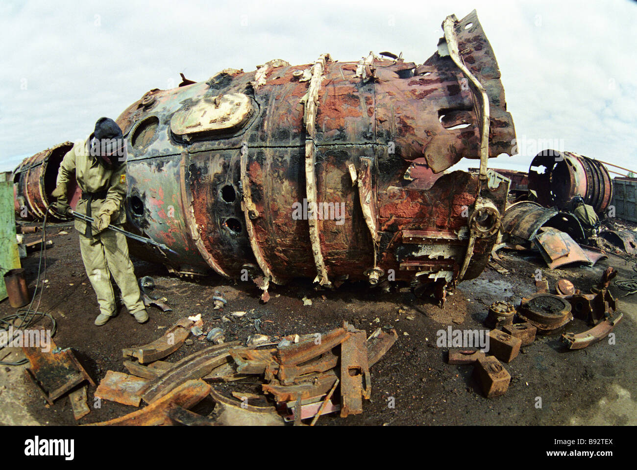 A welder in protective suit cuts the body of a nuclear powered ...