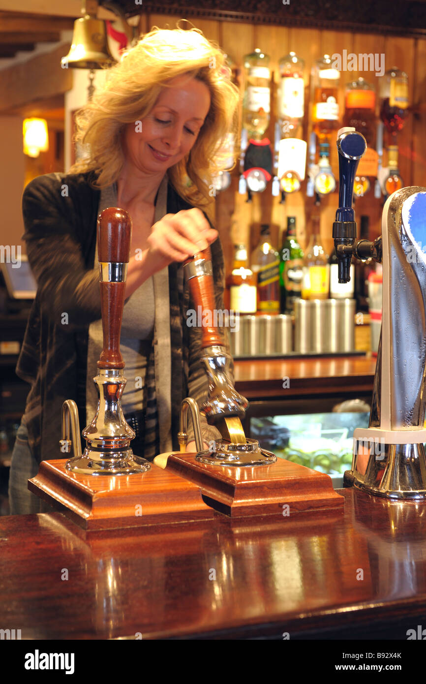 barmaid pulling a pint from a hand pump Stock Photo - Alamy