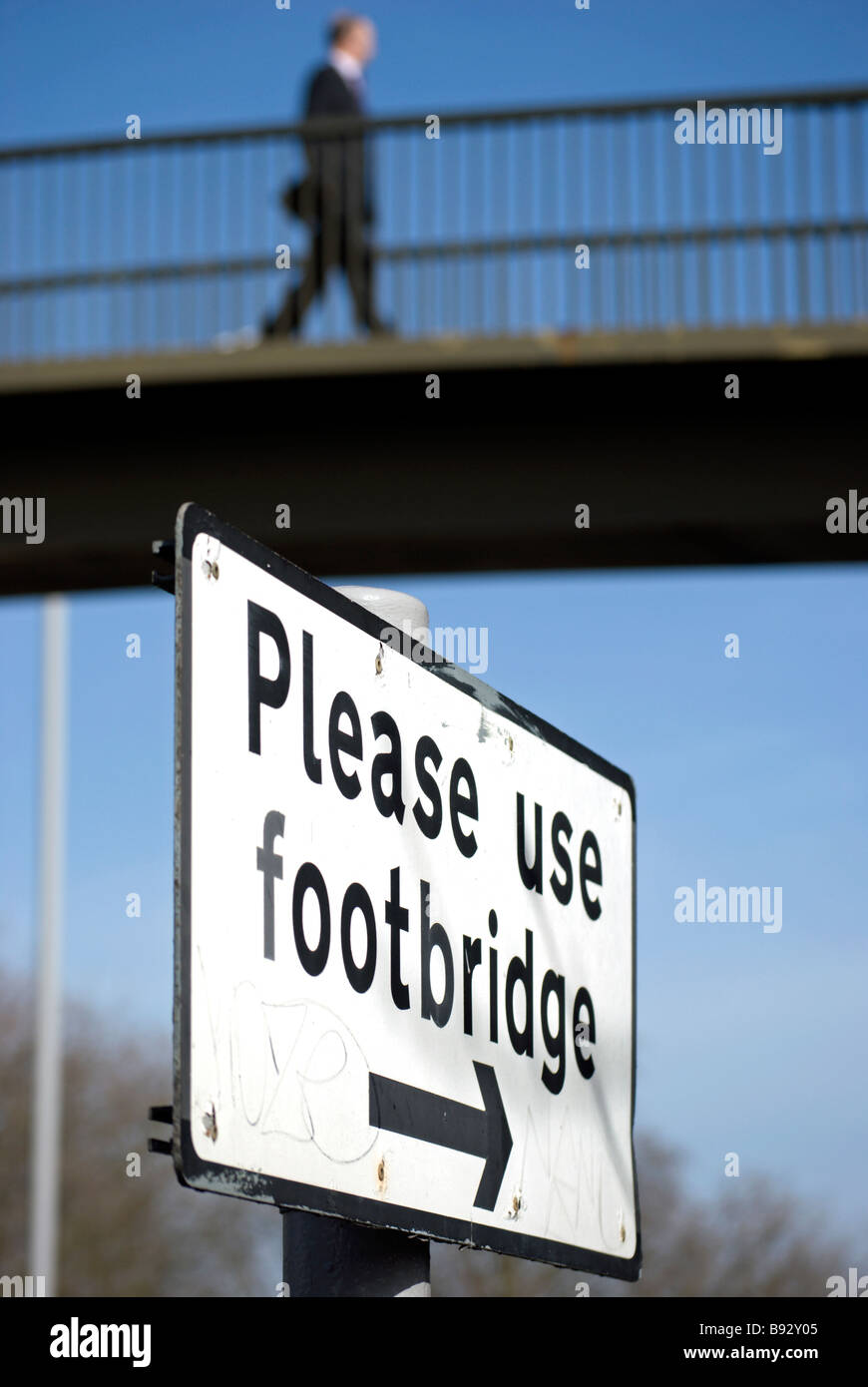 british please use footbridge road sign with man crossing footbridge in ...