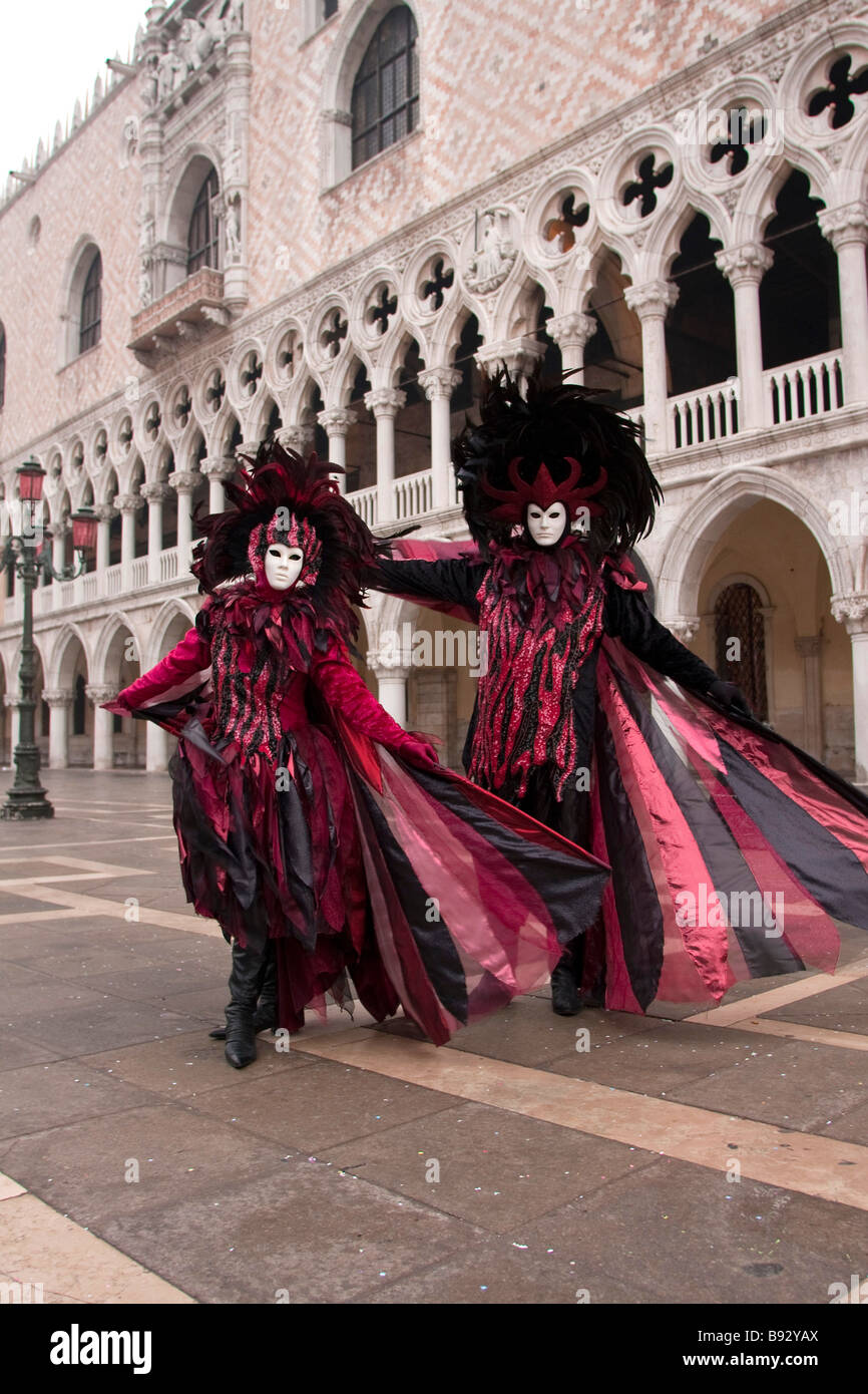 Venice Carnival. 2 characters red pink hat Costume & mask feathers San Marco. Venice Veneto ...