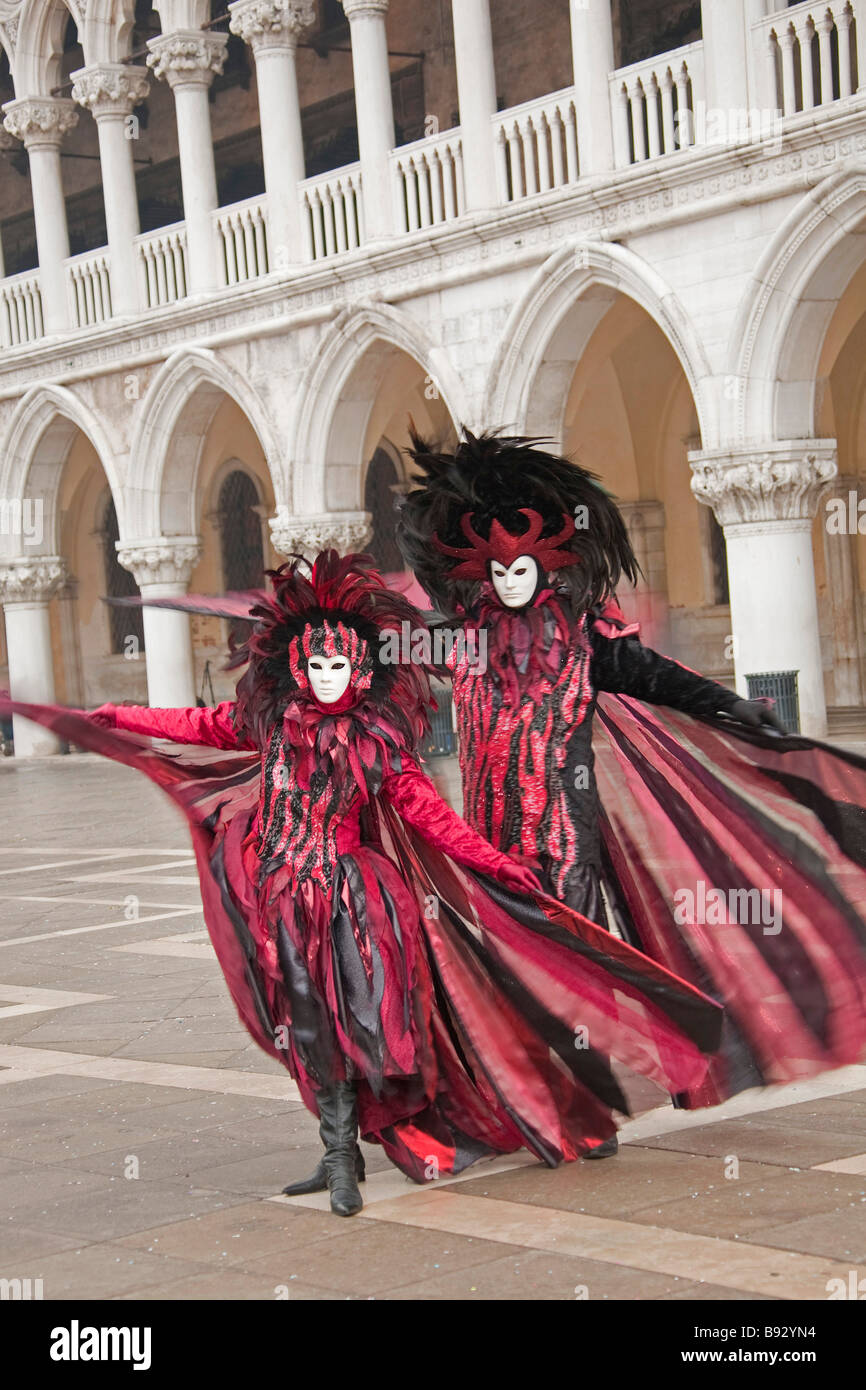 Venice Carnival. 2 characters red pink hat Costume & mask feathers San Marco. Venice Veneto ...