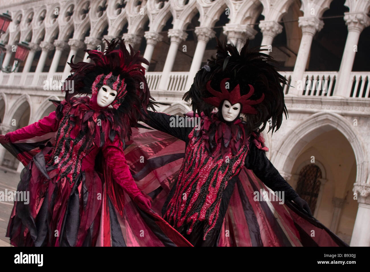 Venice Carnival. 2 characters red pink hat Costume & mask feathers San Marco. Venice Veneto ...