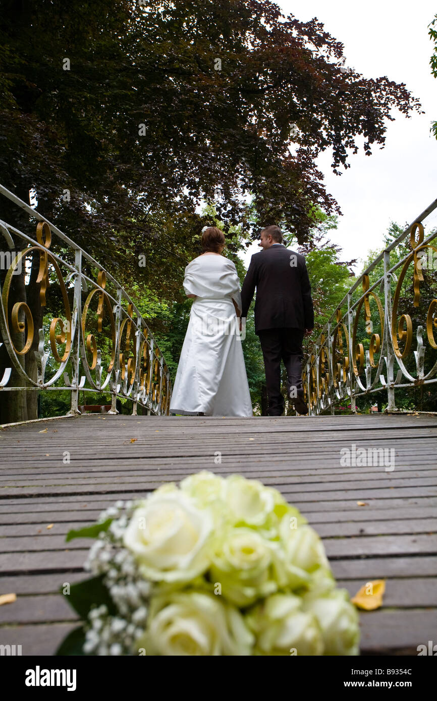 Wedding bouquet with newly wed couple, husband and wife, walking over a ...