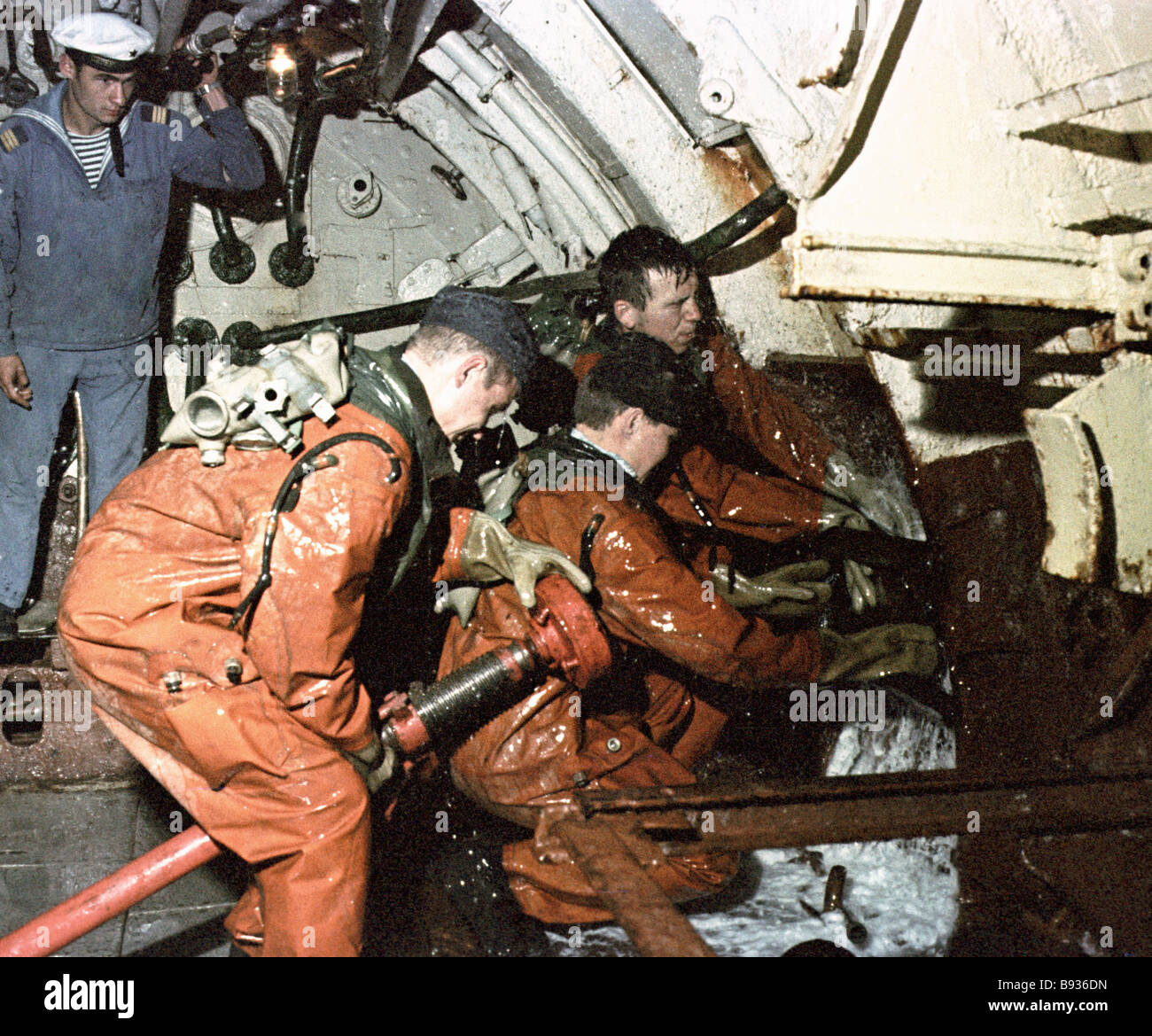 Submariners plugging a hole of streaming water during training on a ...