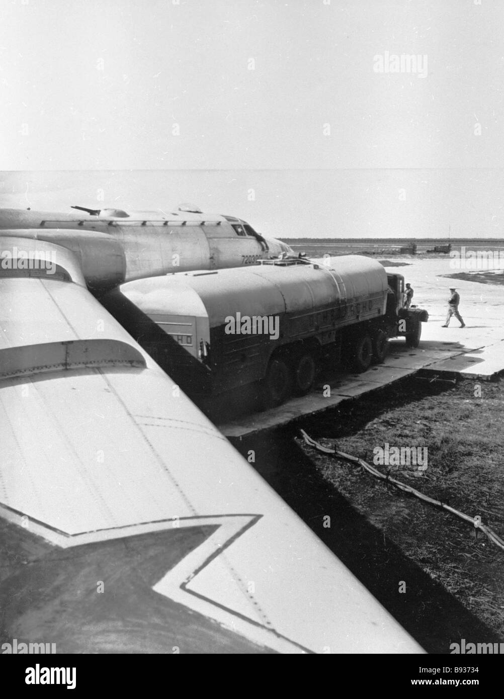Gasolene tanks pump fuel into flying tanker which is used for mid air ...