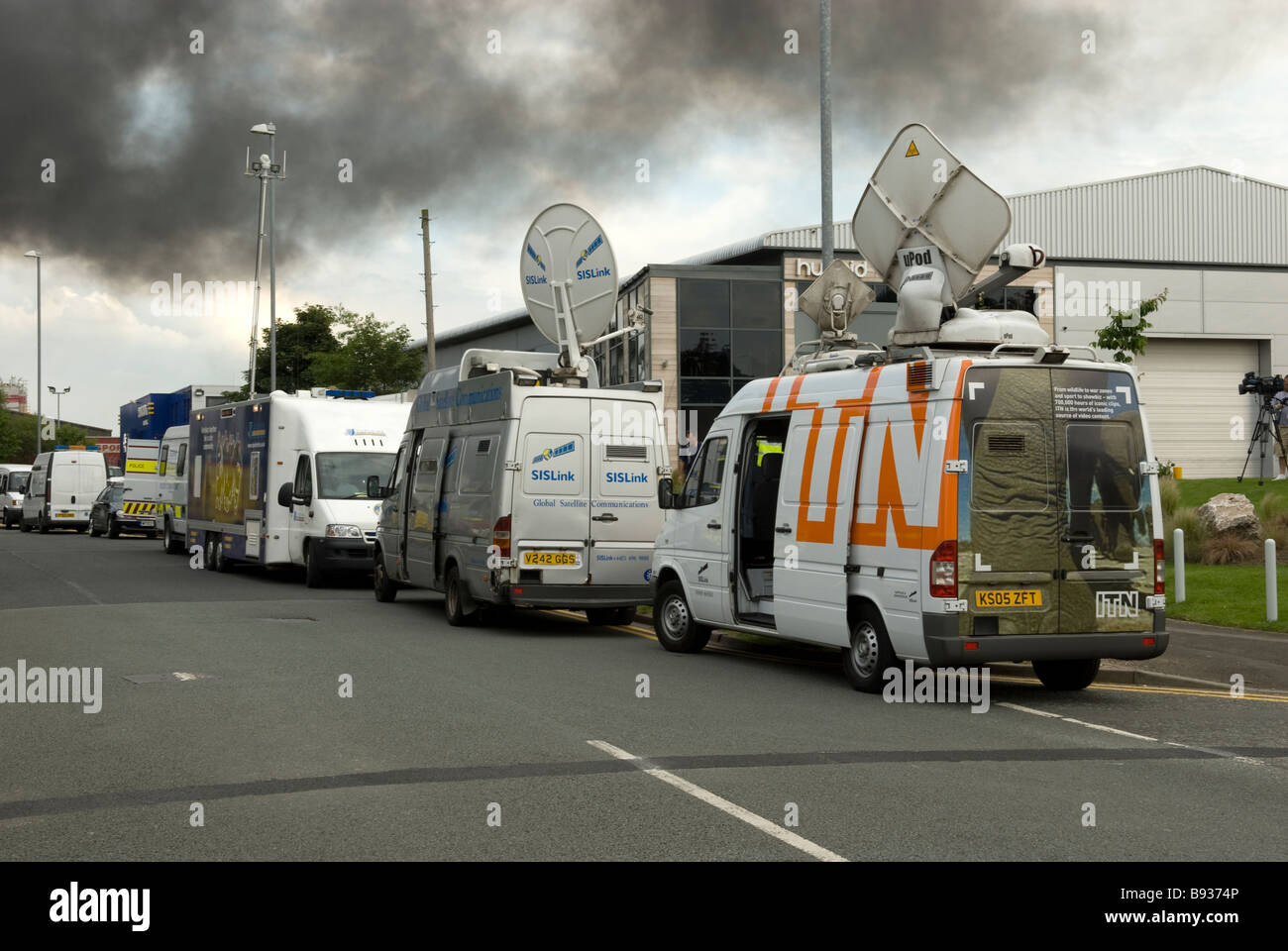 Several news satellite outside broadcast vans at scene of major fire ...