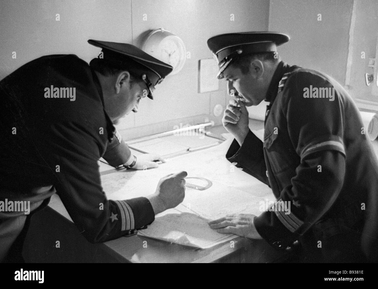 Officers checking the ship s course on a chart during an exercise ...