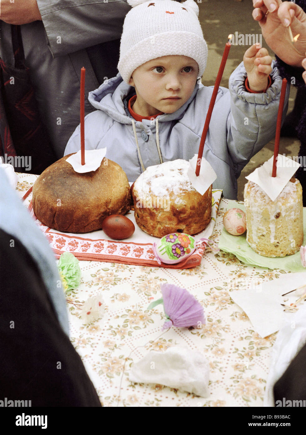 A girl shields the candlelight from the wind at the blessing of Easter ...