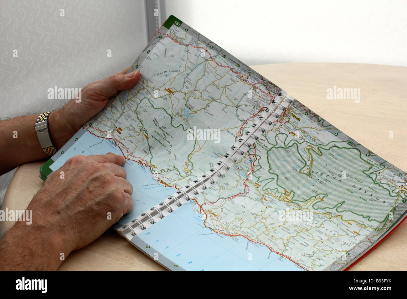 Man Looking at a Book of Maps Stock Photo - Alamy