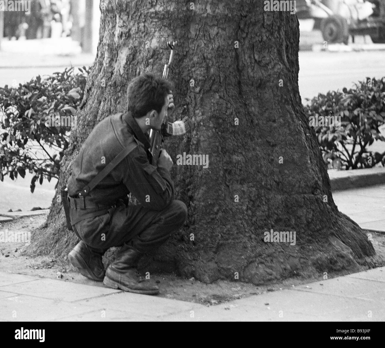 A militant with an assault rifle behind a tree during unrest on ...