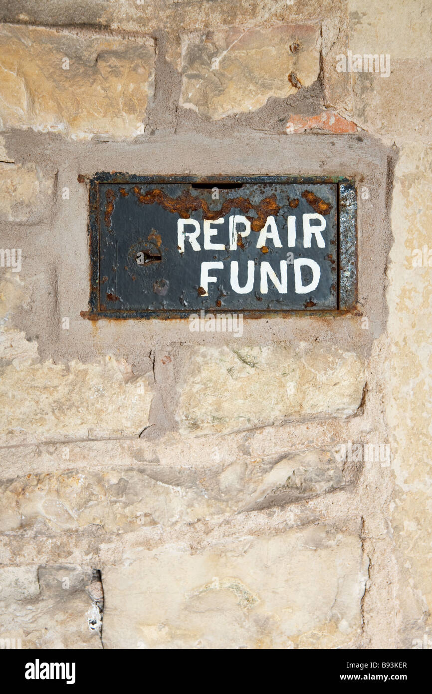 A corroded 'repair fund' money collection box embedded into a church ...
