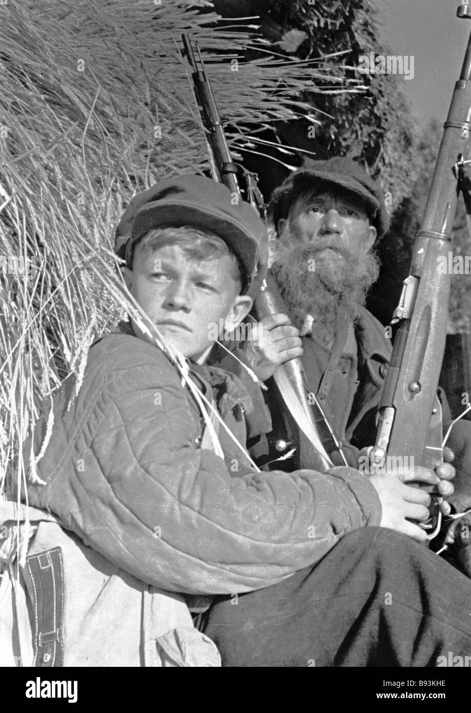An old man and a boy with rifles hiding in a stack Stock Photo - Alamy