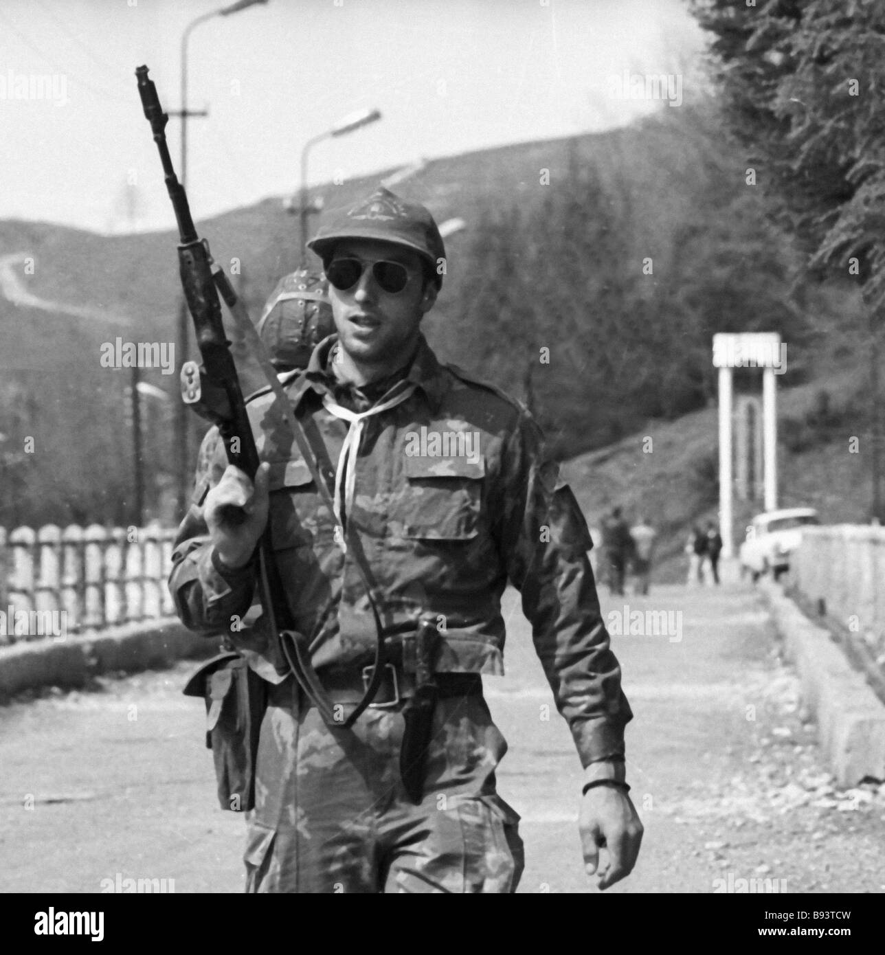 A government soldier with an assault rifle at the ready walking down ...