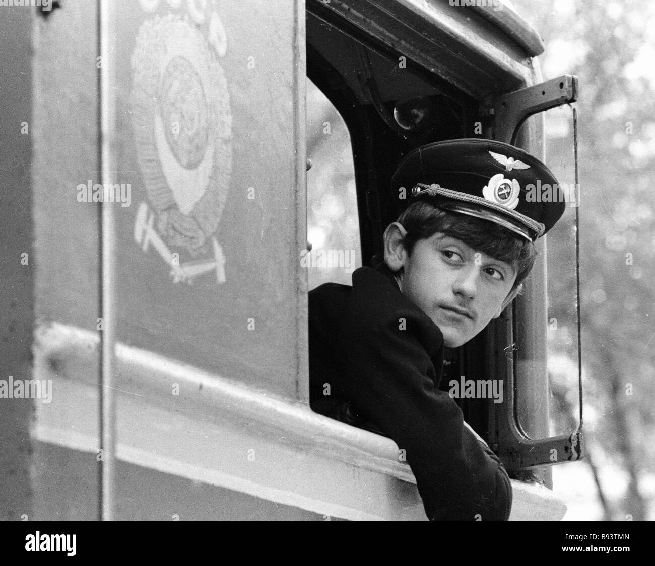 A young locomotive engineer looks out of a locomotive cabin A railway ...
