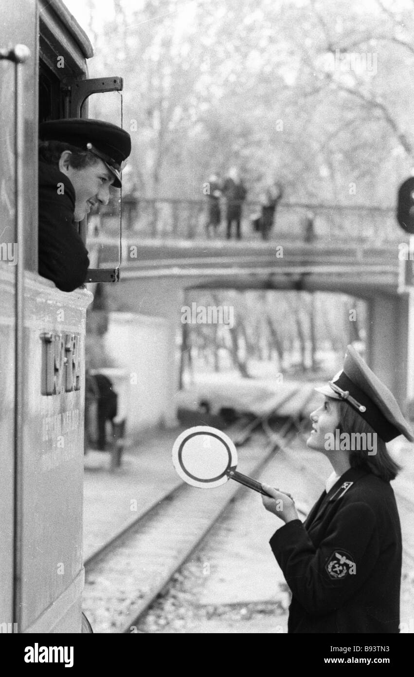 A railway station worker and a young locomotive engineer at a railway ...