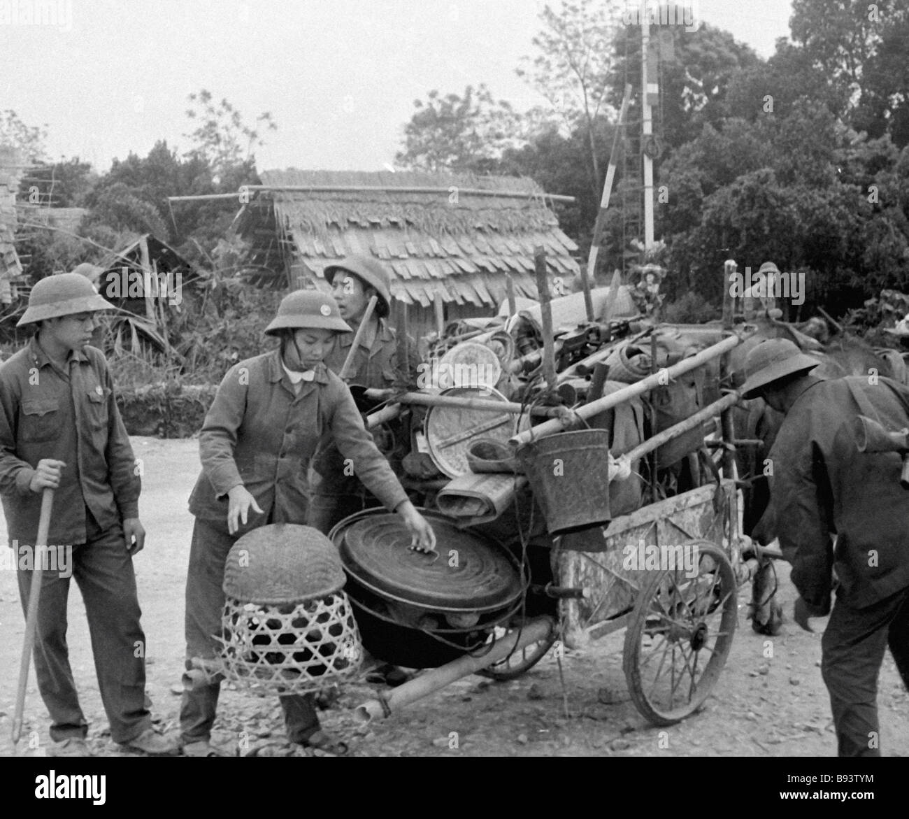 Vietnamese militiamen helping refugees load carts with their belongings ...