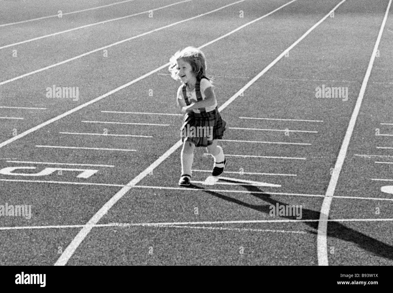 A little girl on a stadium race track Stock Photo - Alamy