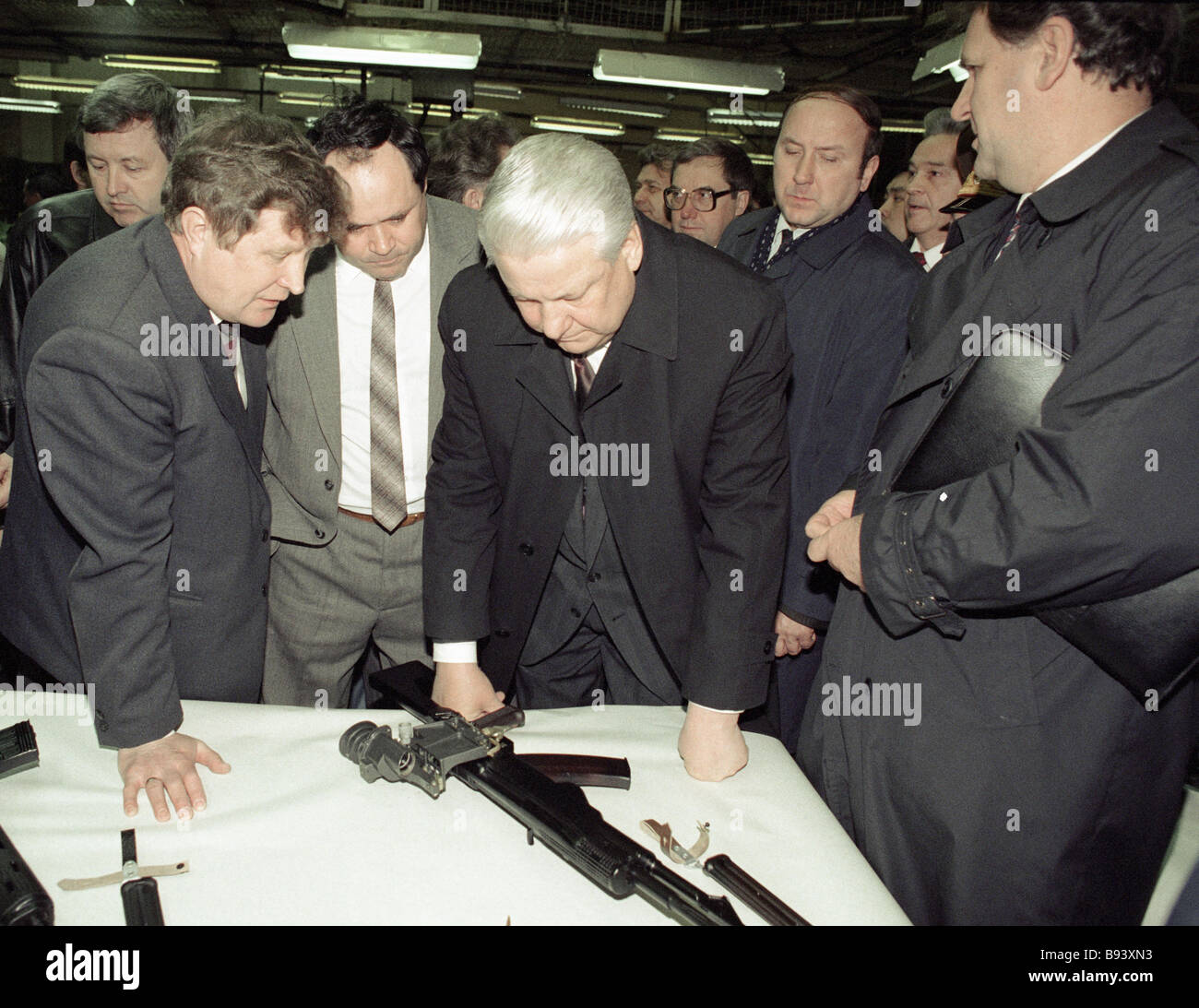 Russian President Boris Yeltsin center examining a Kalashnikov machine ...