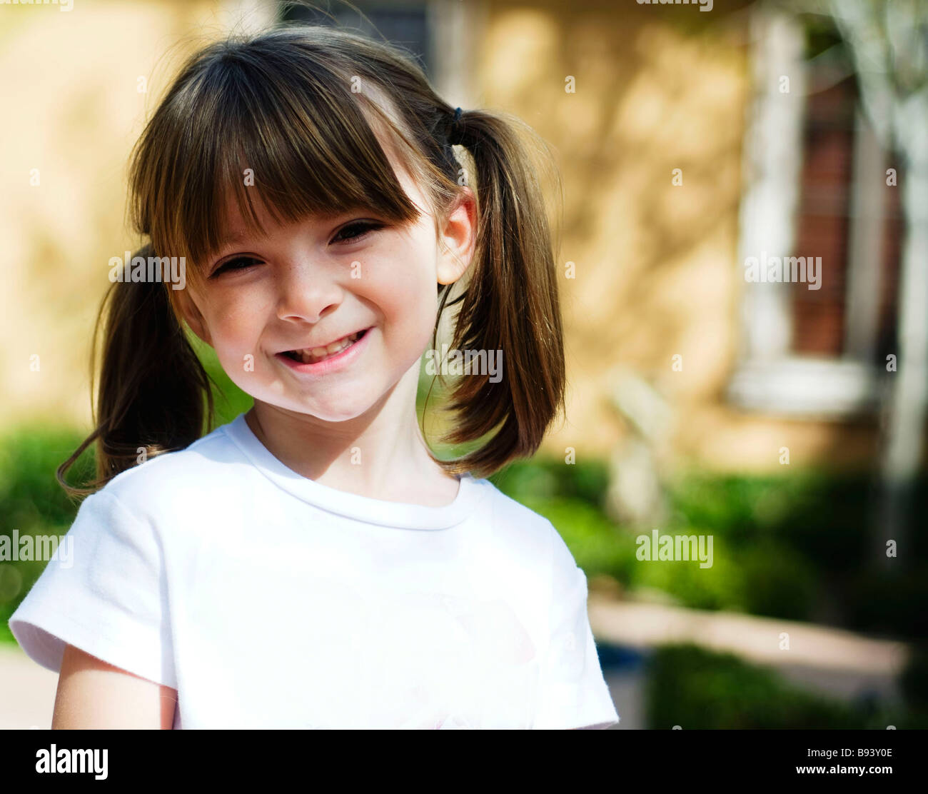 Adorable little girl aged four with pig tails in her hair Stock Photo ...