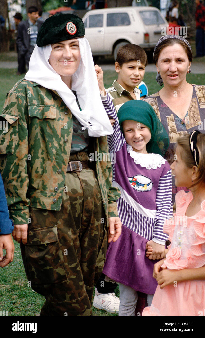 A member of an armed Chechen group with her family in a Grozny street ...