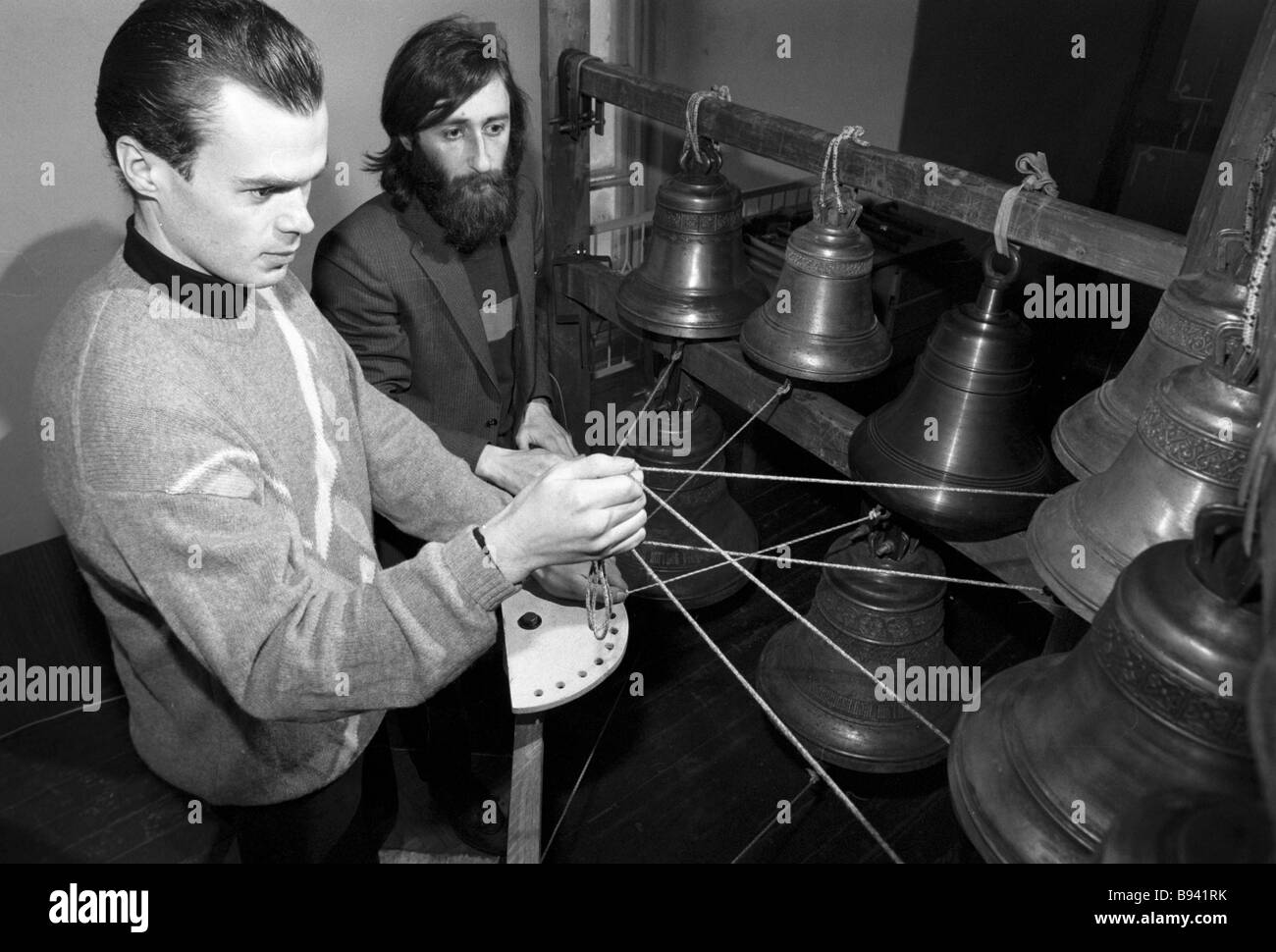 A bell ringer right giving lessons to one of the worshippers left of ...
