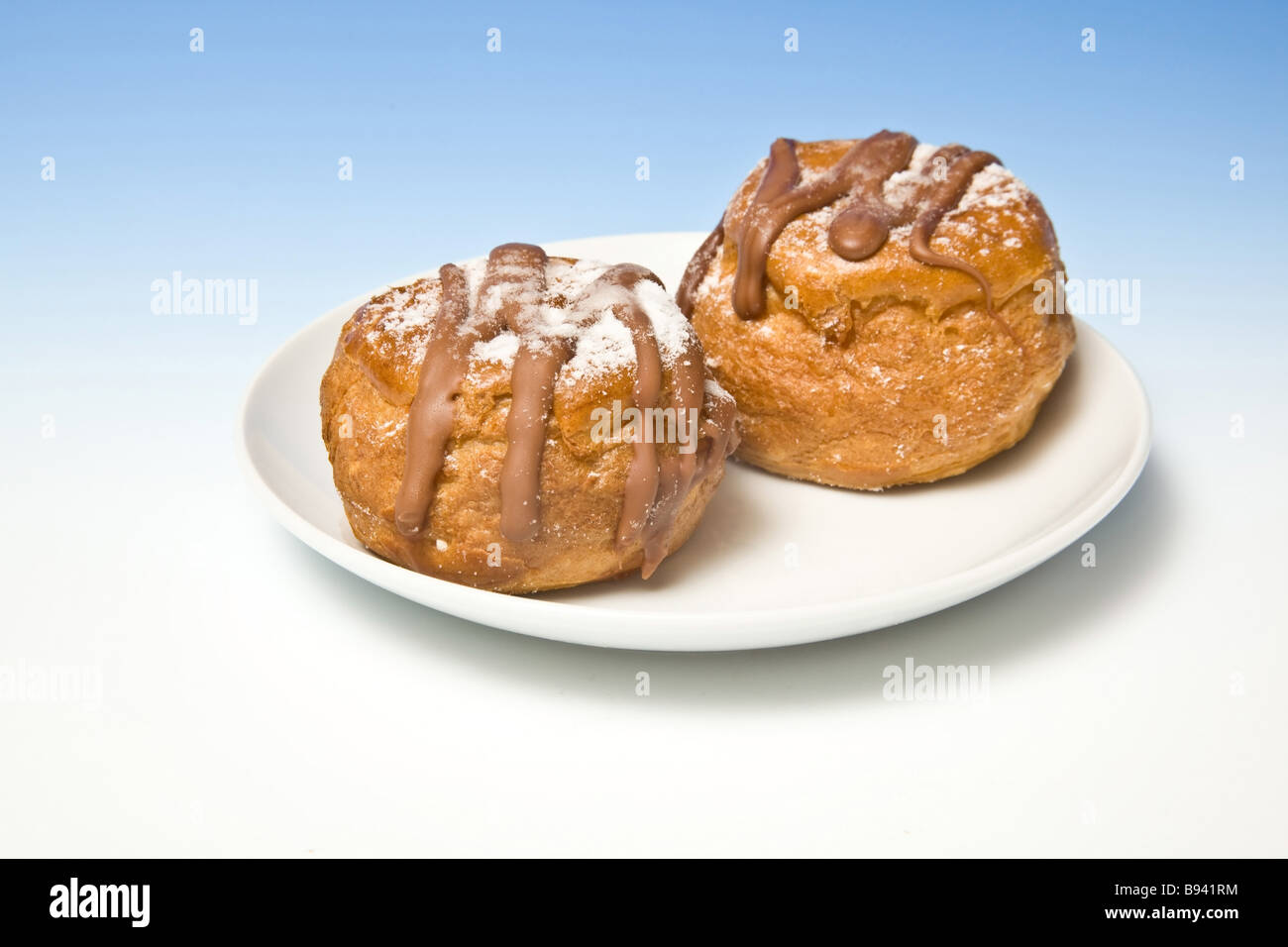 Cream buns on a graduated blue studio background Stock Photo - Alamy