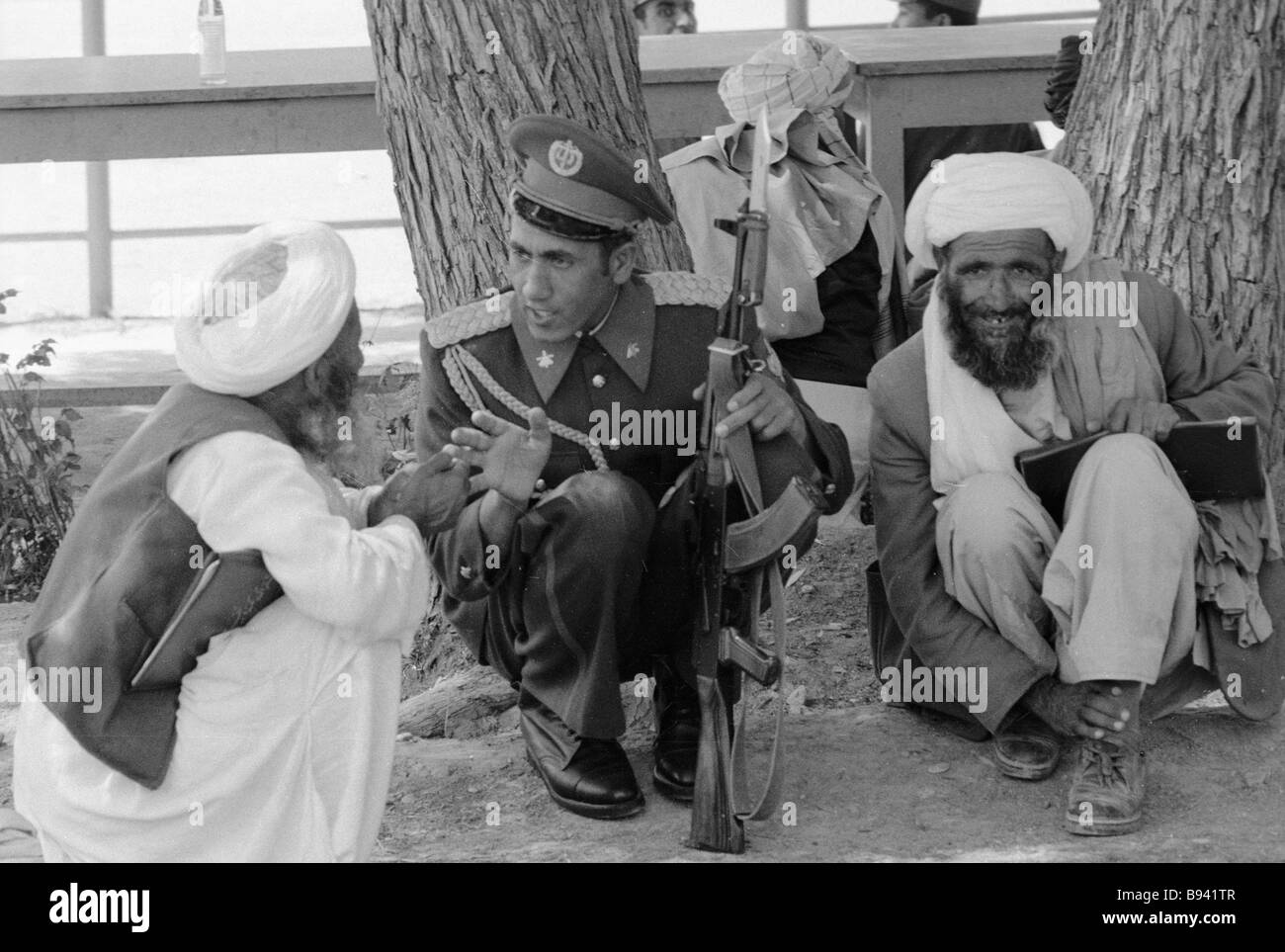 An Afghan soldier talks to the elders of the village Stock Photo - Alamy