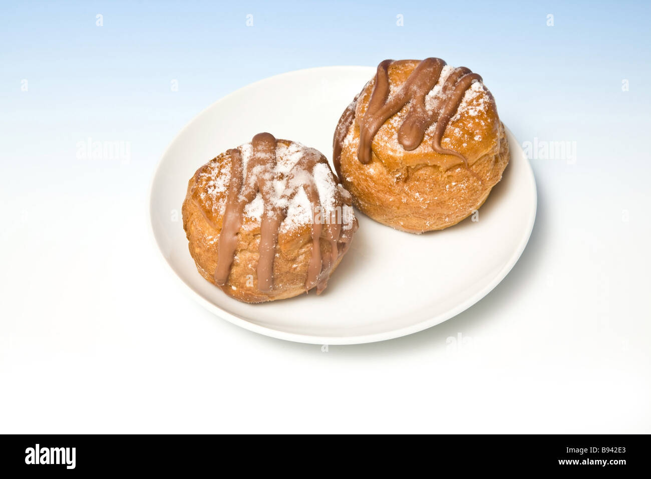 Cream buns on a graduated blue studio background Stock Photo - Alamy