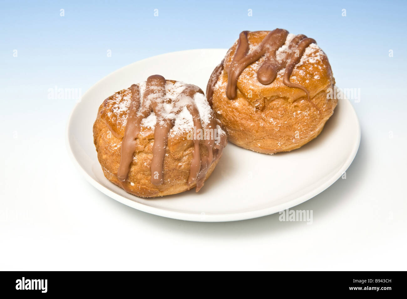 Cream buns on a graduated blue studio background Stock Photo - Alamy
