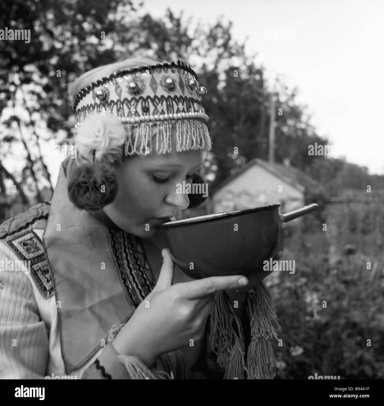 Girl wearing national Mordovian clothes drinking water Stock Photo - Alamy