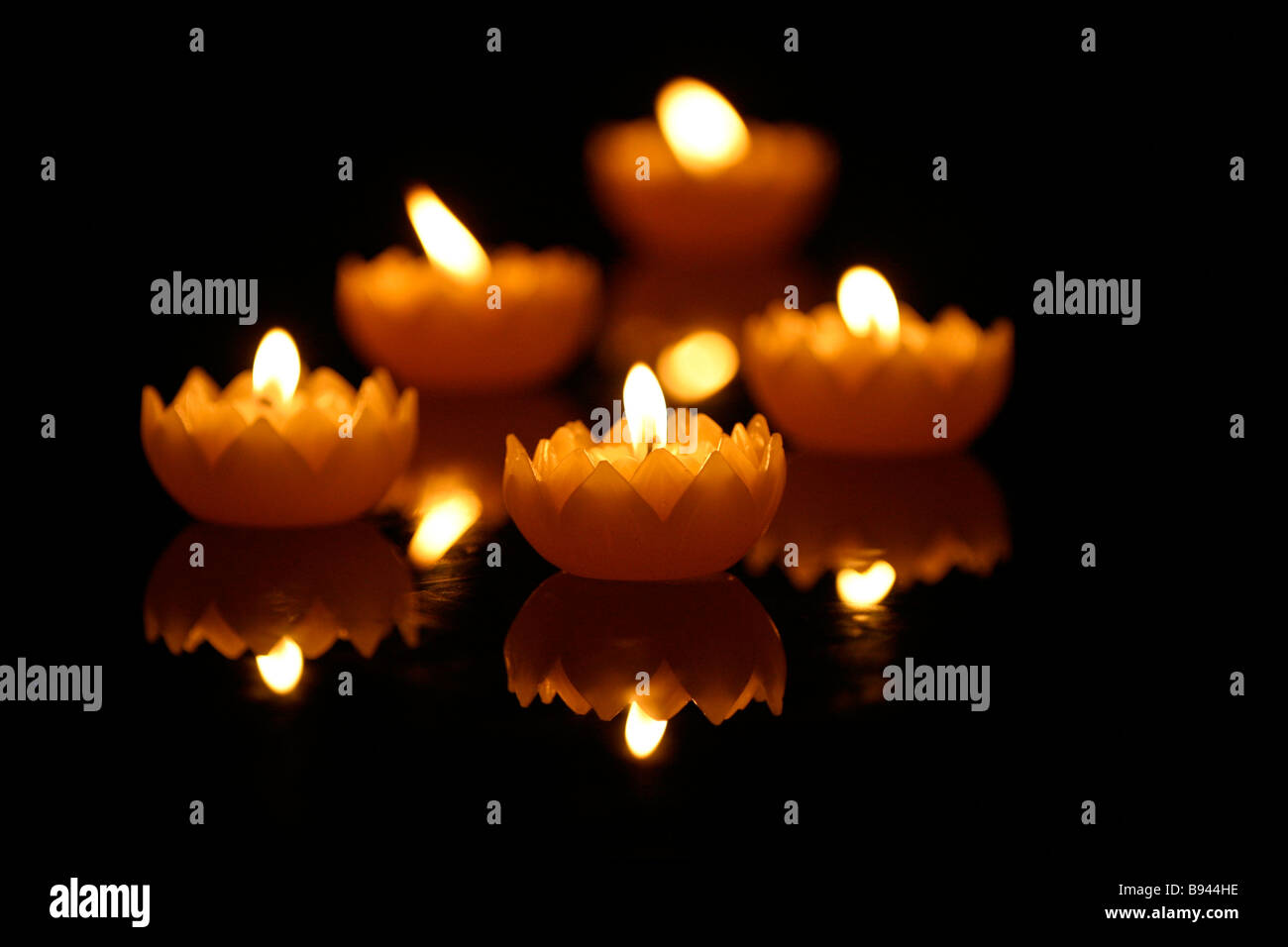 Attractive group of candles on a reflective surface Stock Photo - Alamy