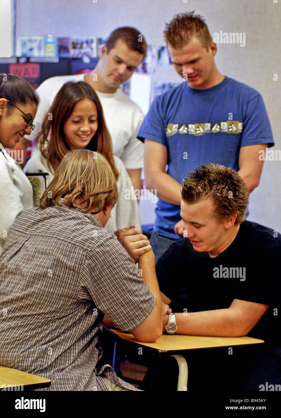 Relaxing after class two high school boys arm wrestle while classmates ...