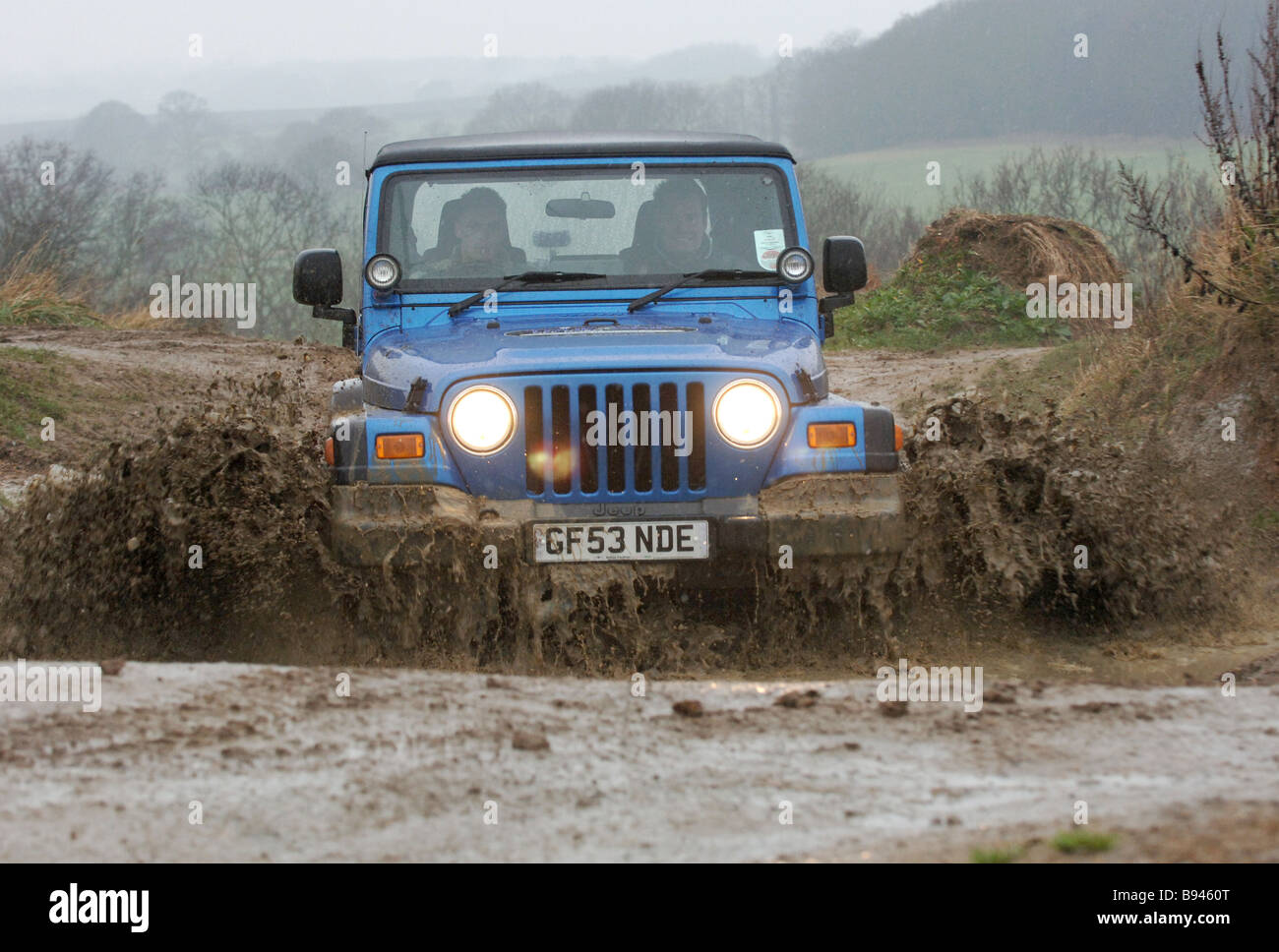 Jeep Wrangler splashes through deep water off road Stock Photo - Alamy