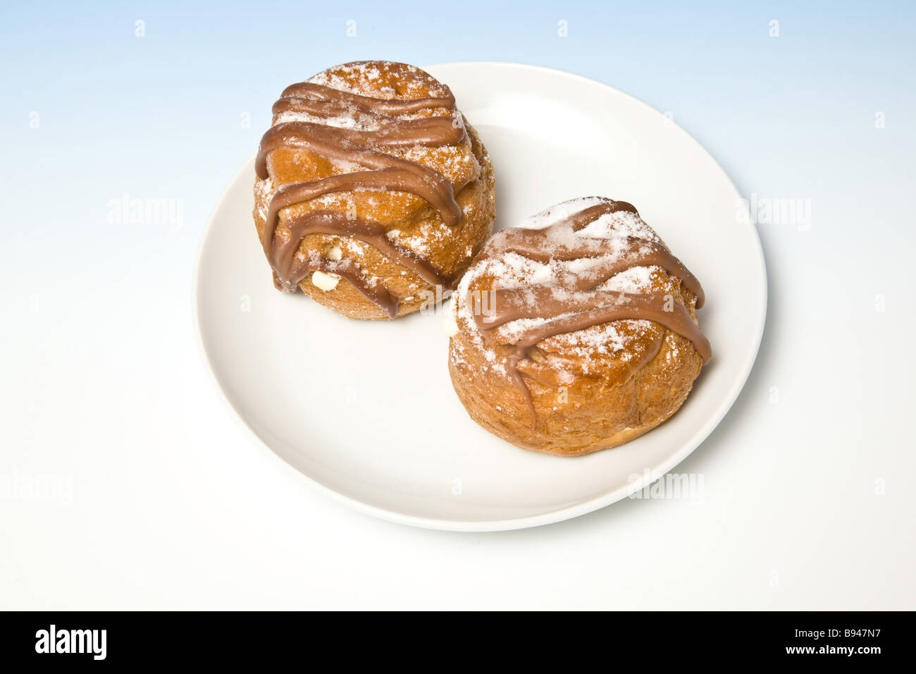 Cream buns on a graduated blue studio background Stock Photo - Alamy