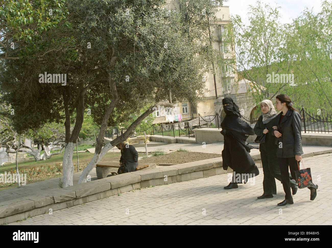 Three women in a Baku street one wearing yashmac another with a hijab ...