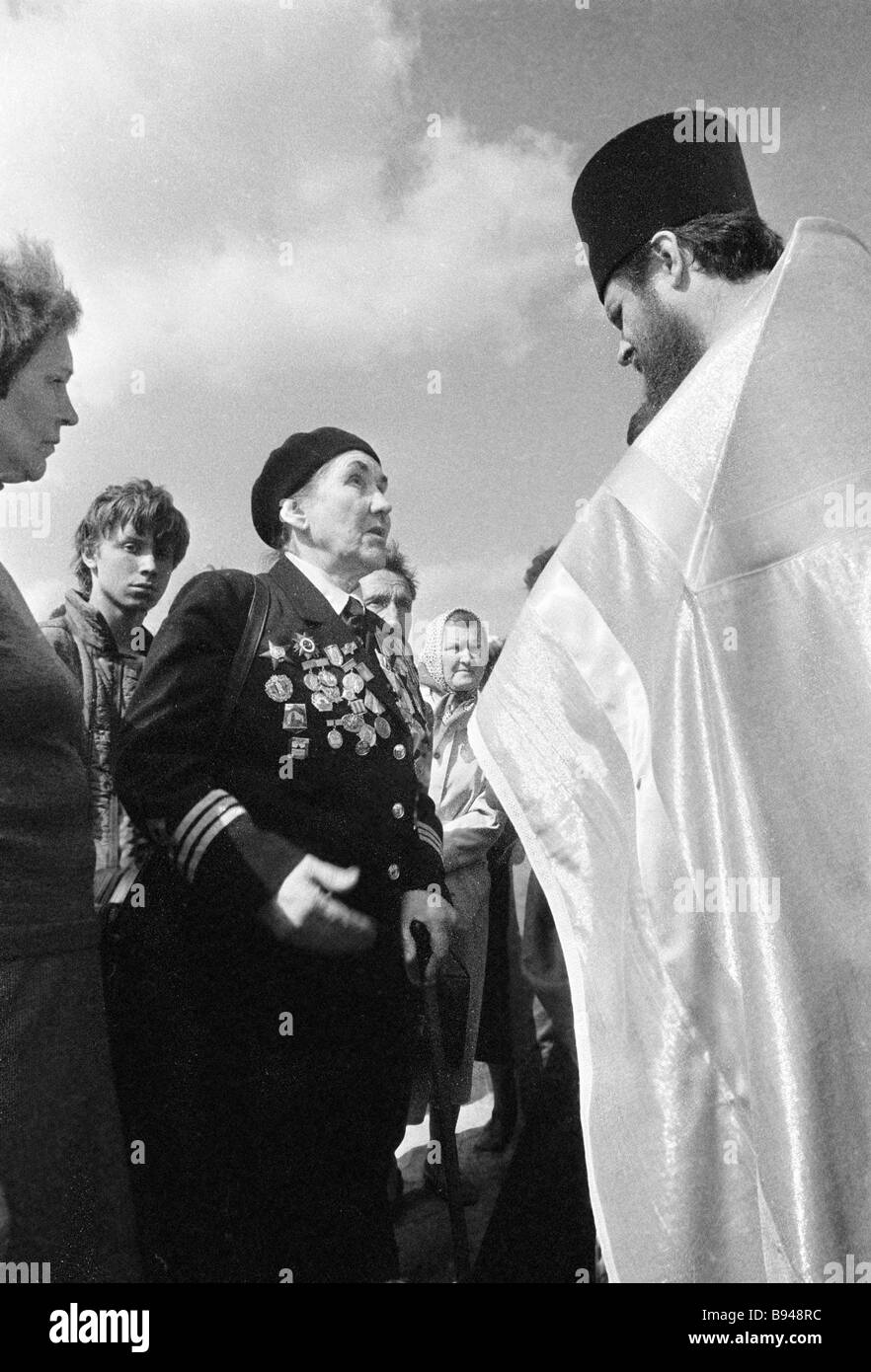 A priest administering funeral rites for the remains of soldiers who ...