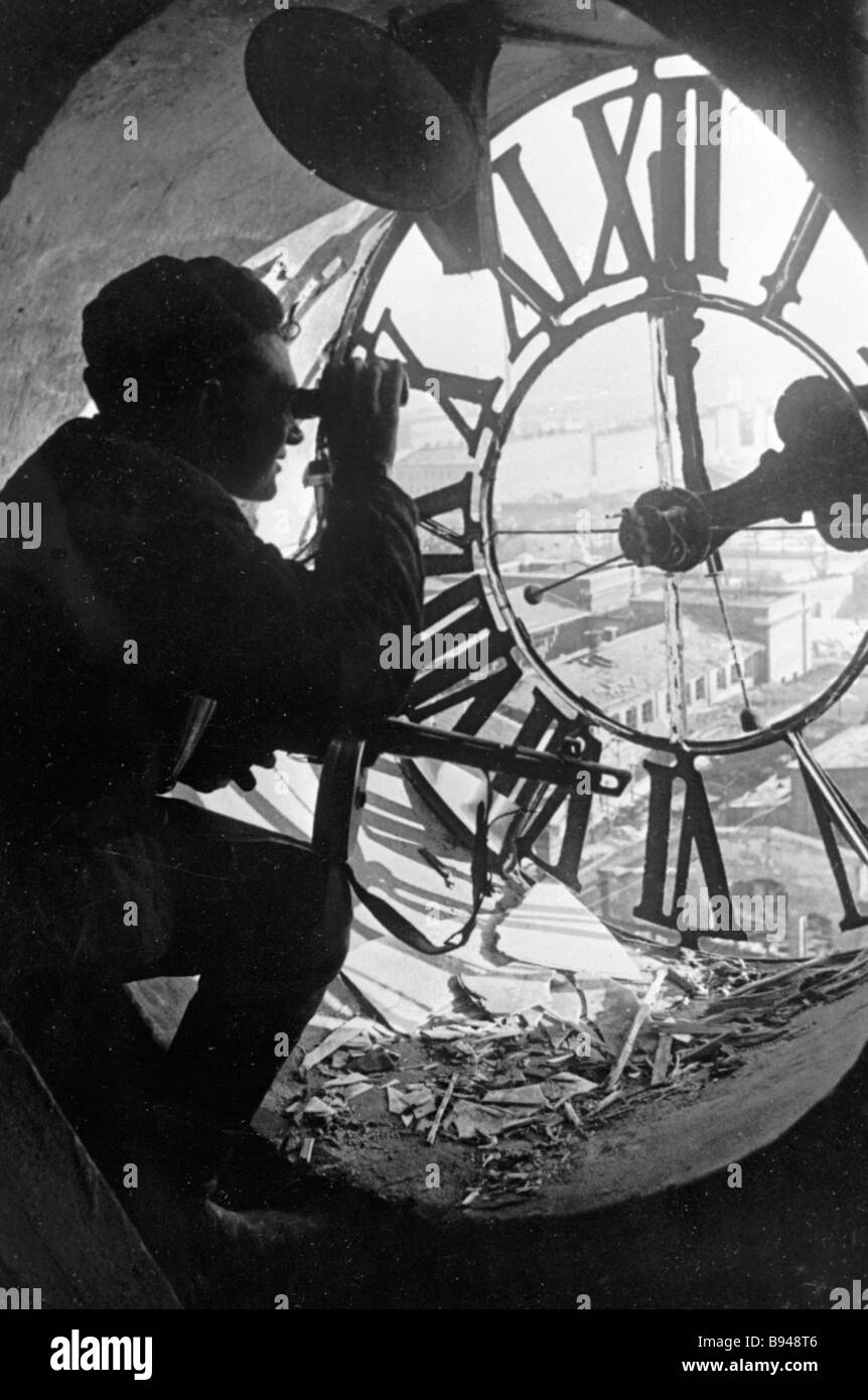 A soldier with a submachine gun and binoculars in a clocktower Stock ...
