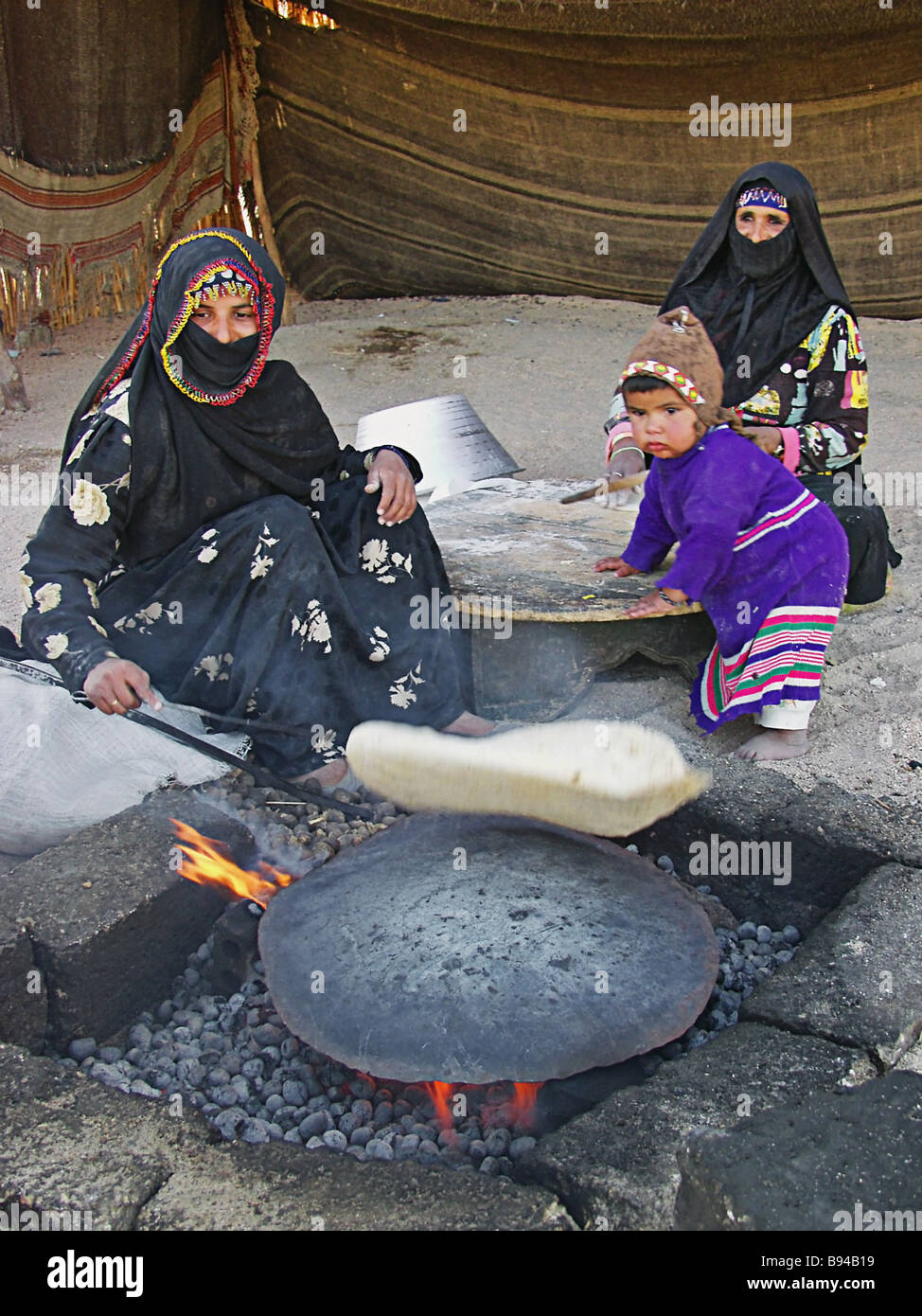 A Bedouin family baking bread in Sahara Stock Photo - Alamy