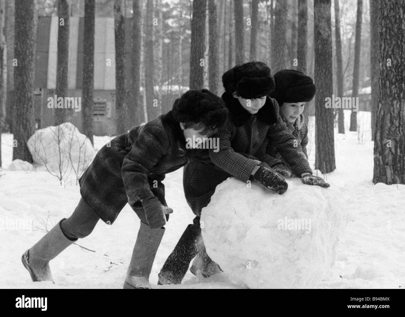 Students of forest school make large snowball Stock Photo - Alamy