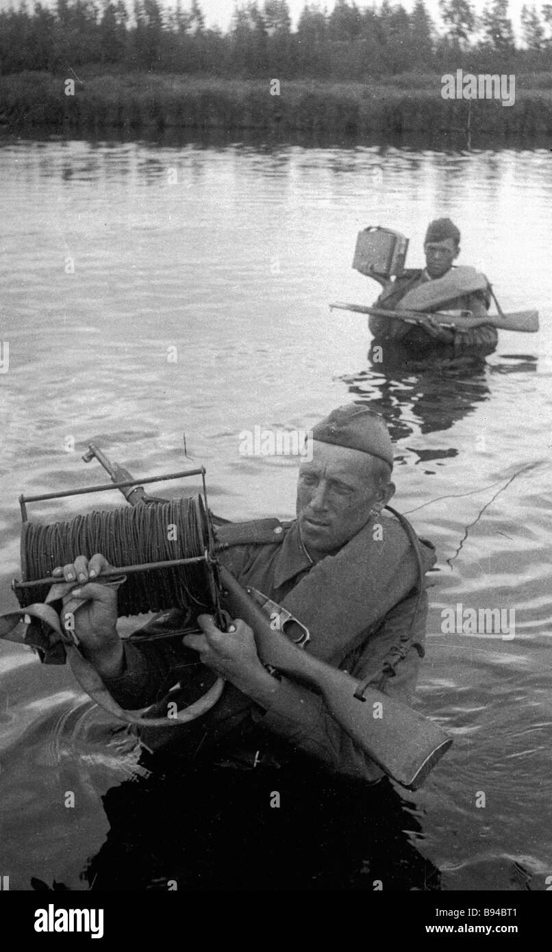 Soviet signallers laying communication line across river Stock Photo ...