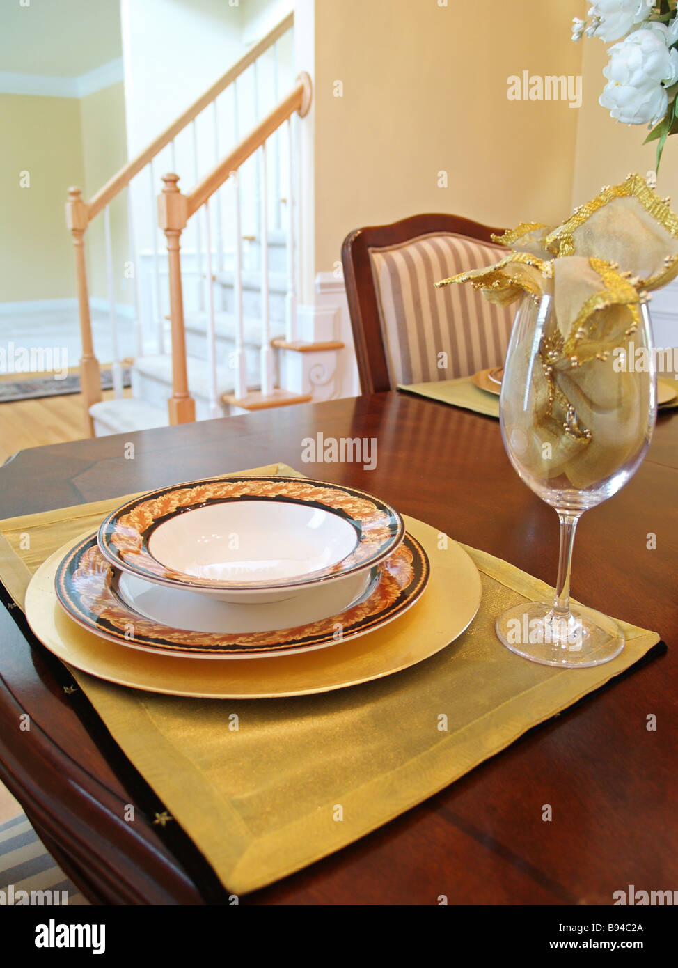 A gold place setting on the dining room table Stock Photo - Alamy