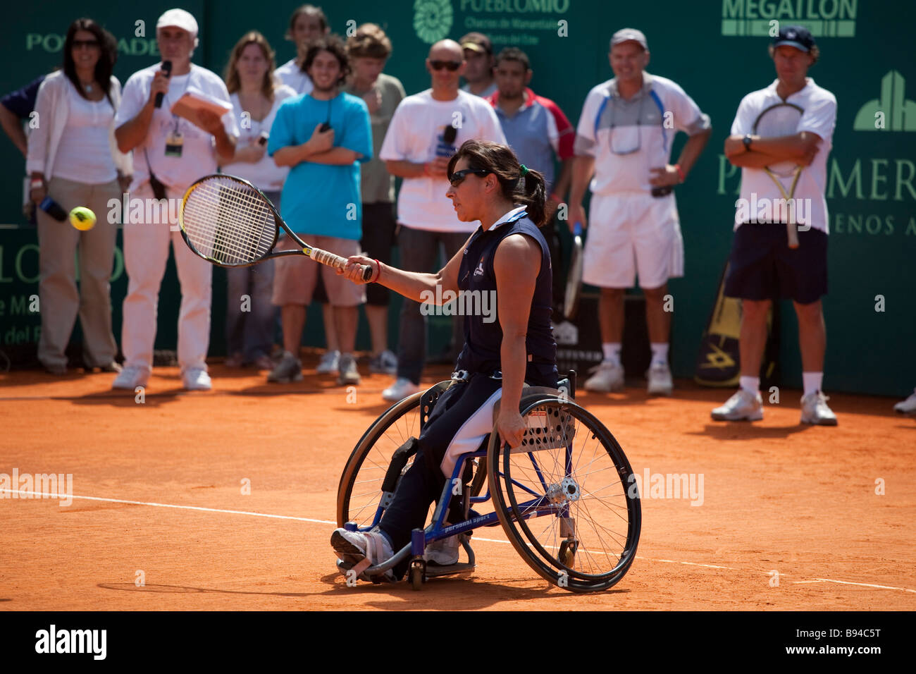 A handicapped female tennis player hitting a drive in a fundraising ...