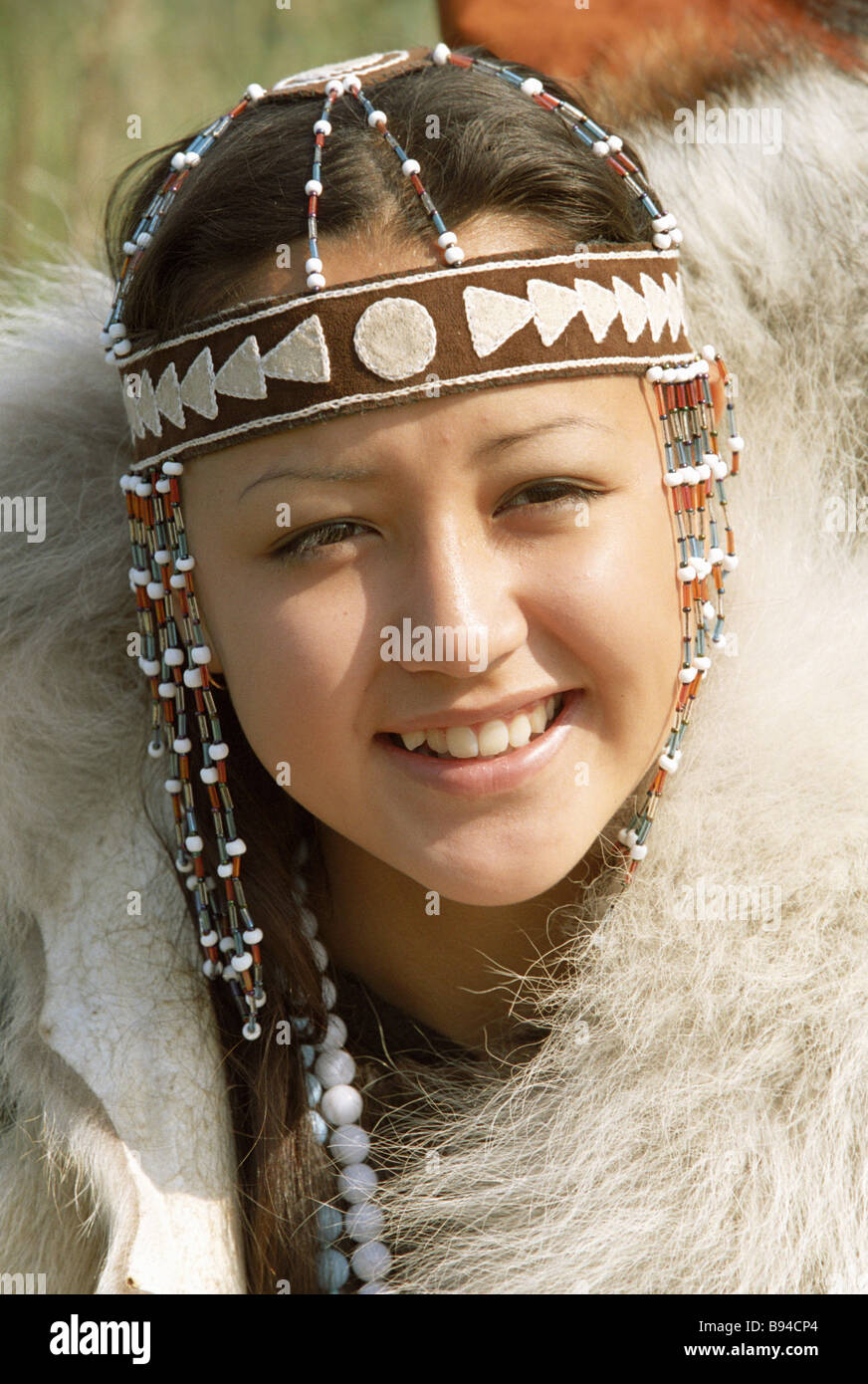 Member of the Chukotka song and dance ensemble wearing a national head ...