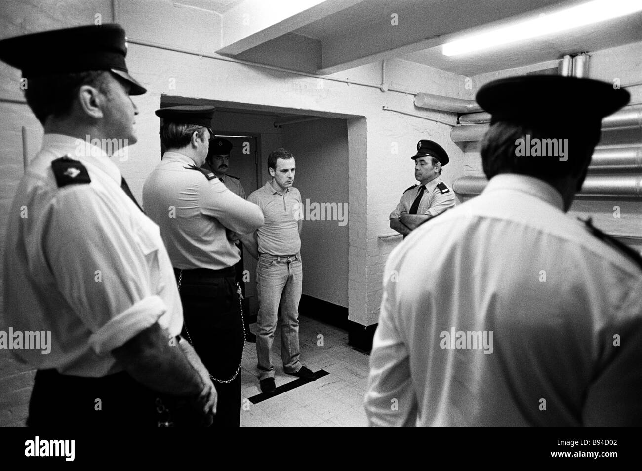 Prison officers watch over a prisoner toeing the line during an ...