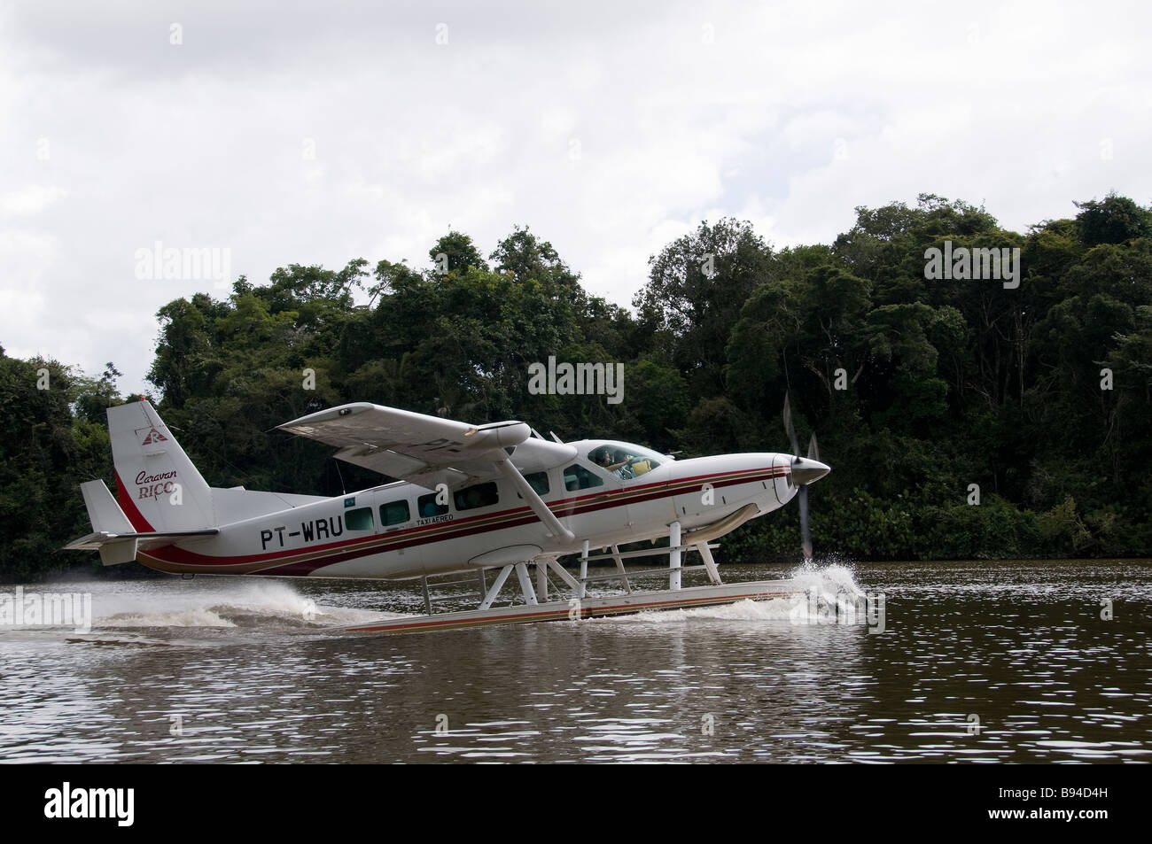 A Caravan float plane takes off from a small blackwater tributary that ...