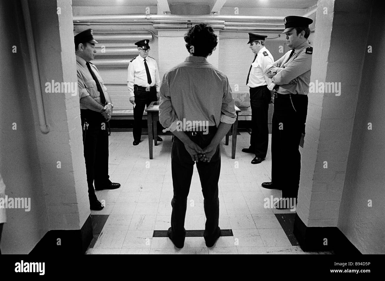 Prison officers watch over a prisoner toeing the line during an ...
