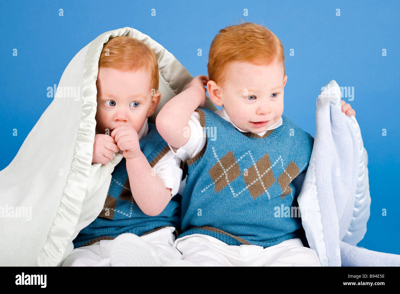 Twin boys set against bright blue background Stock Photo - Alamy