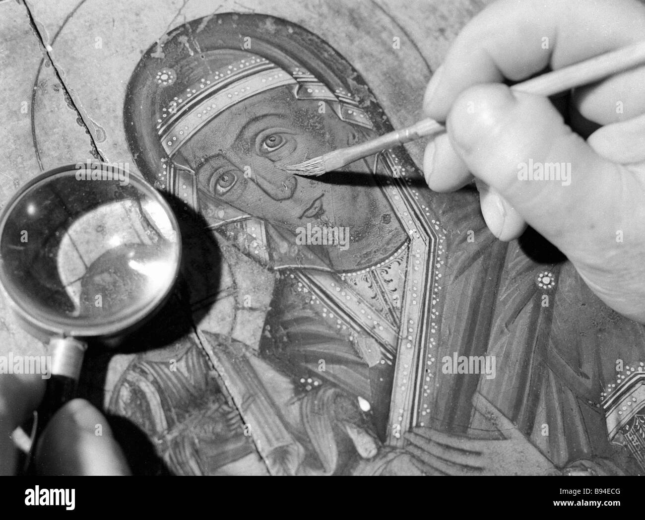 An artist restores an 18th century icon of the Blessed Virgin Stock ...