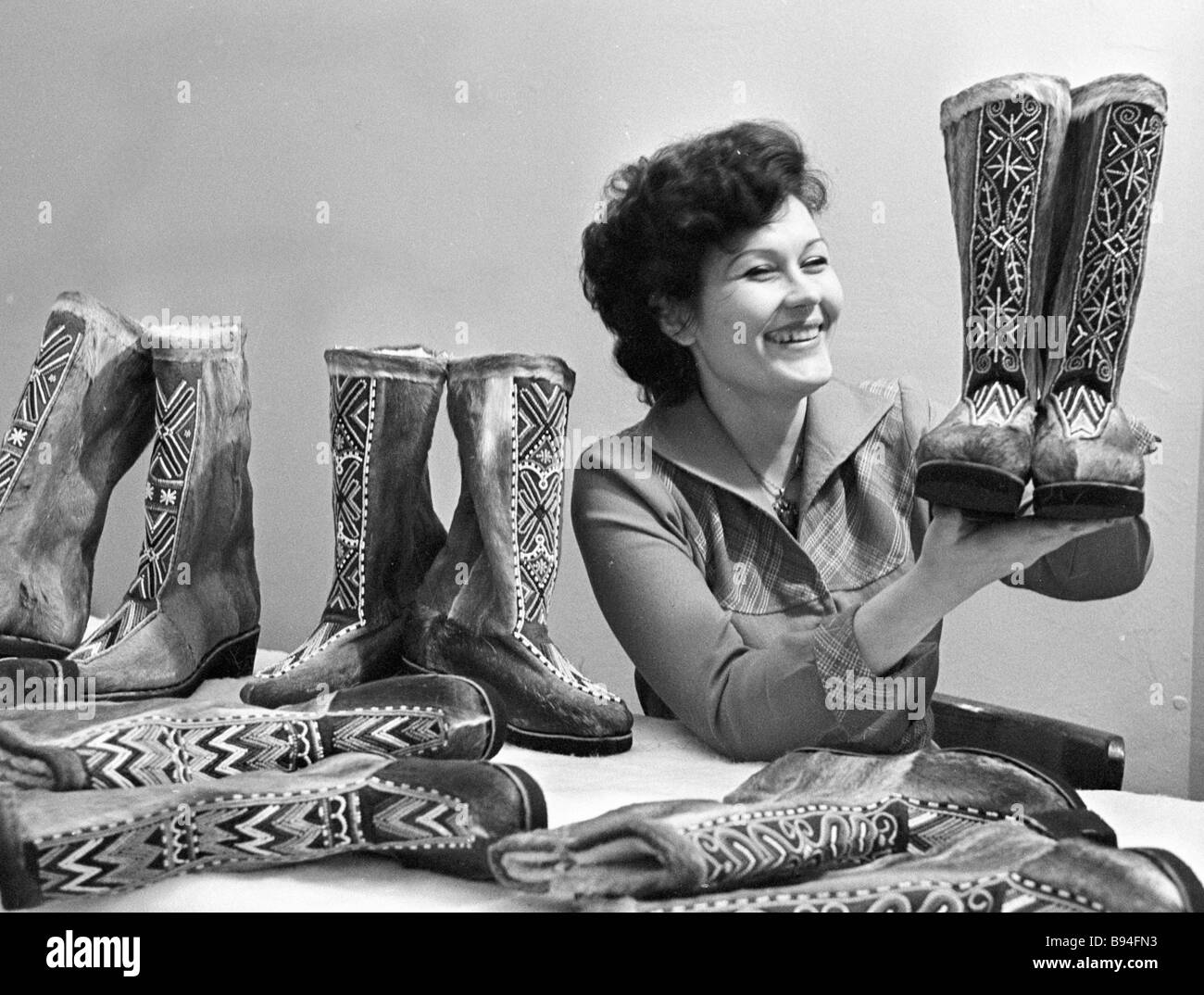 Cobbler displays new reindeer hide boots Stock Photo - Alamy