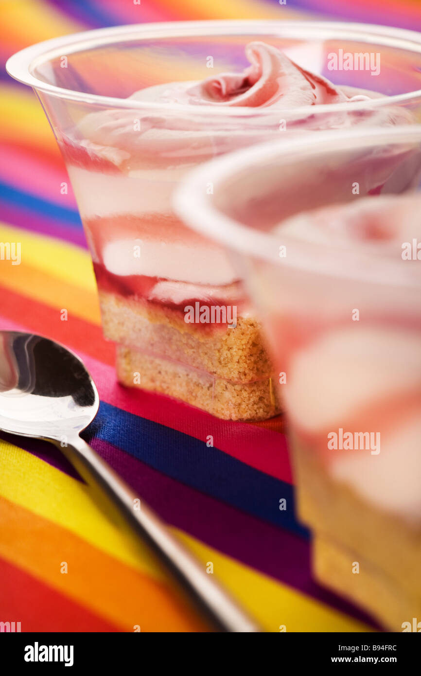Individual pots of strawberry cheesecake on a multiple coloured ...